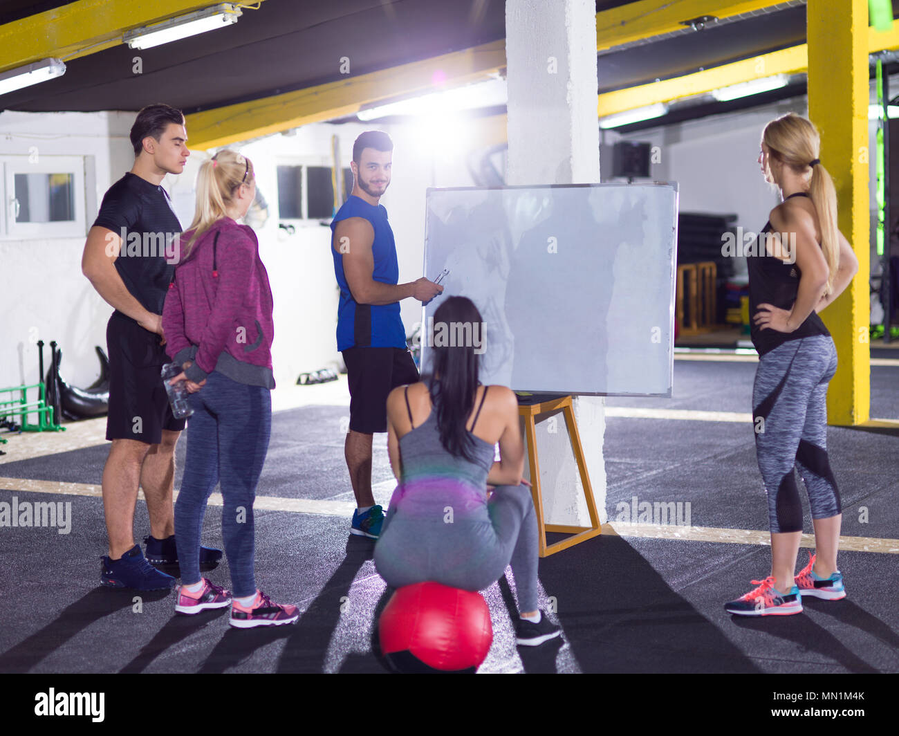 Crossfit training course.group of young athletes getting instructions ...