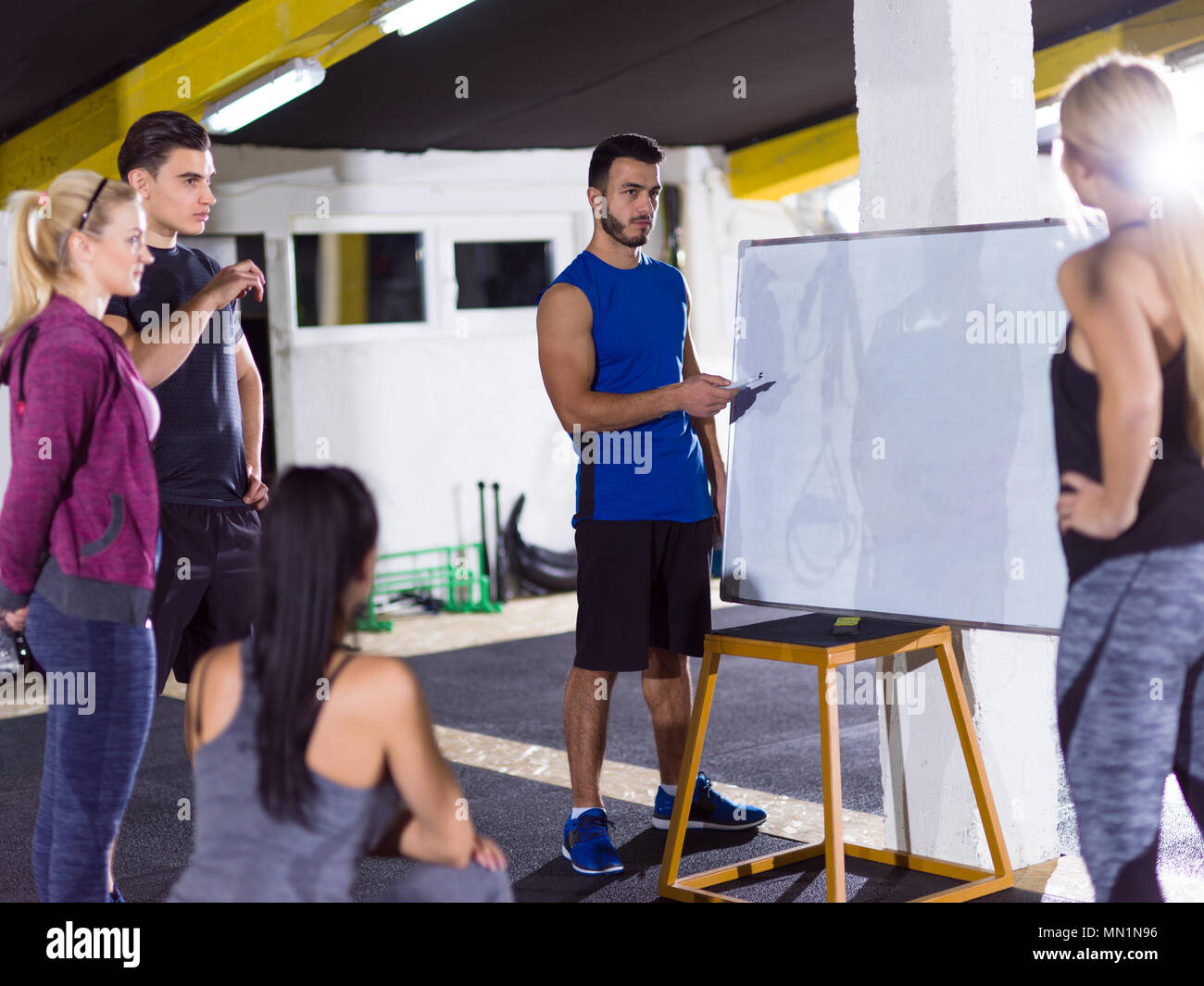 Crossfit training course.group of young athletes getting instructions ...