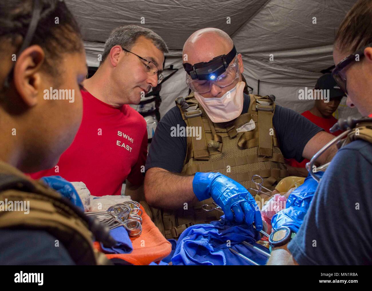 An instructor, center left, looks on as U.S. Navy Cmdr. Michael ...