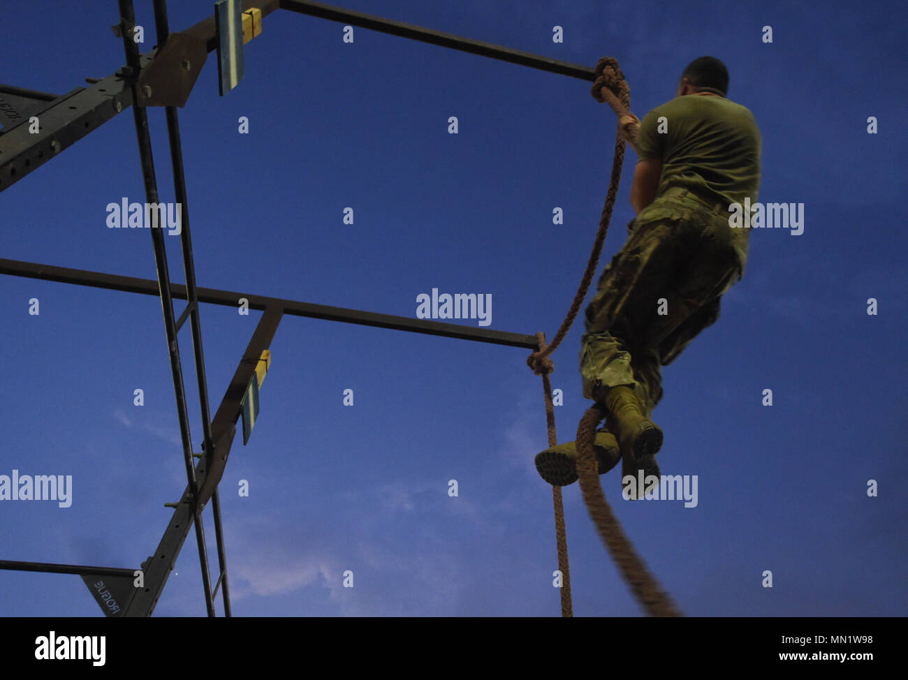 A U.S. service member completes a rope climb during a physical training ...
