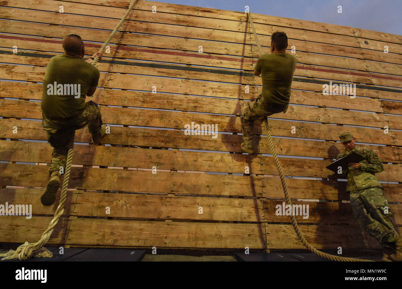 U.S. military members complete a wall rope climb during a physical ...