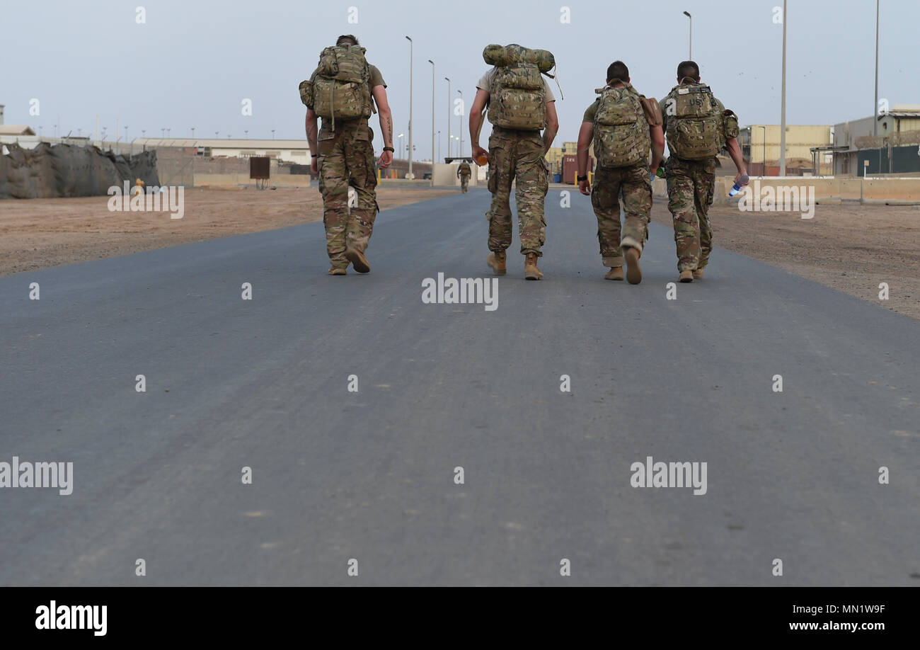U.S. service members participate in a ruck march during a physical ...