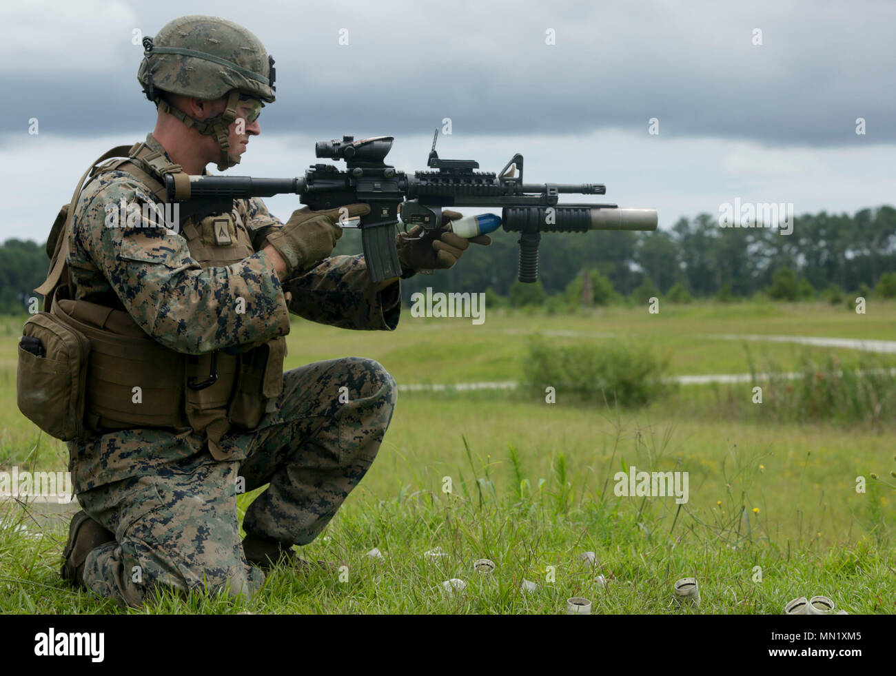 A Marine loads an M203 grenade launcher during a weapons test as part ...