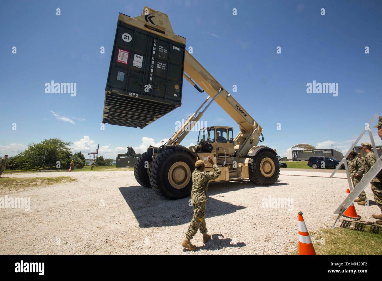 Marines use a kalmar reachstacker to aid them in lifting and offloading ...