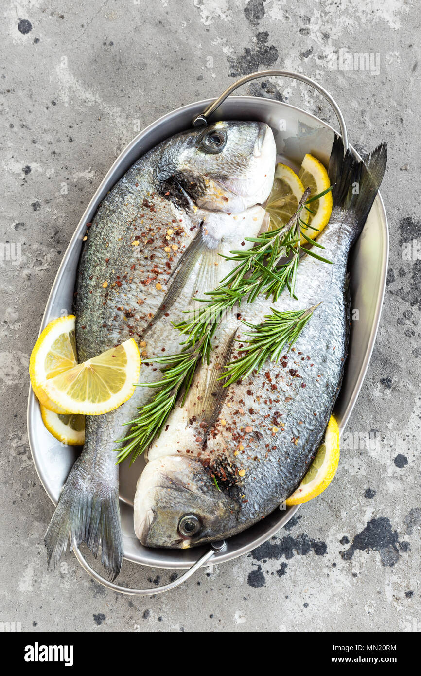 Fresh fish dorado. Raw dorado fish with lemon and rosemary. Sea bream ...