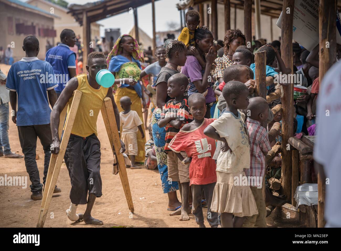 A disabled Congolese refugee seen carrying his food container with his ...