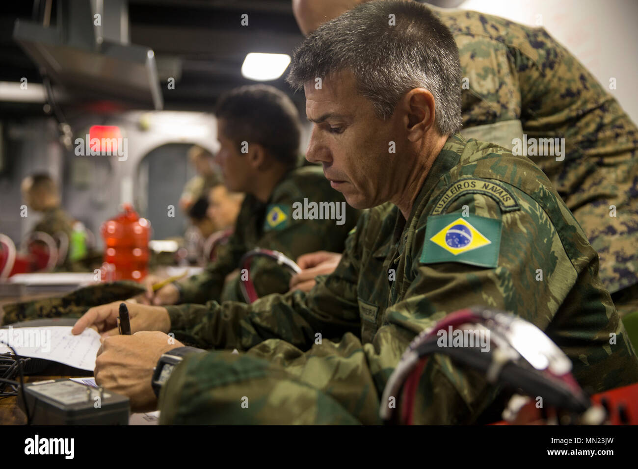 Brazilian marine Capt. de Fragata Marcos Ferreira takes notes during a ...