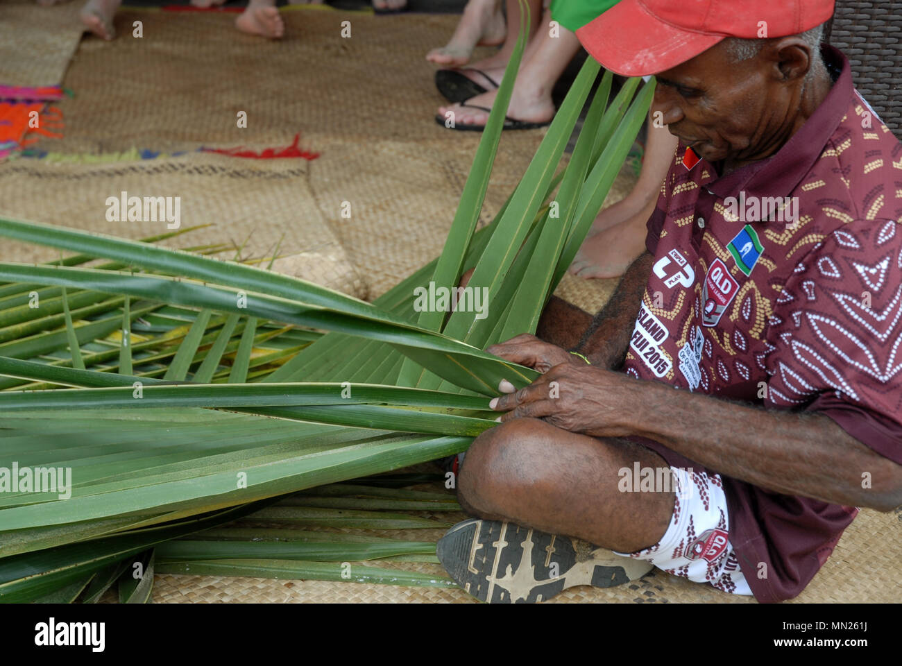 Fijian man creates a basket from weaving a Coconut Palm leaves, Pacific ...
