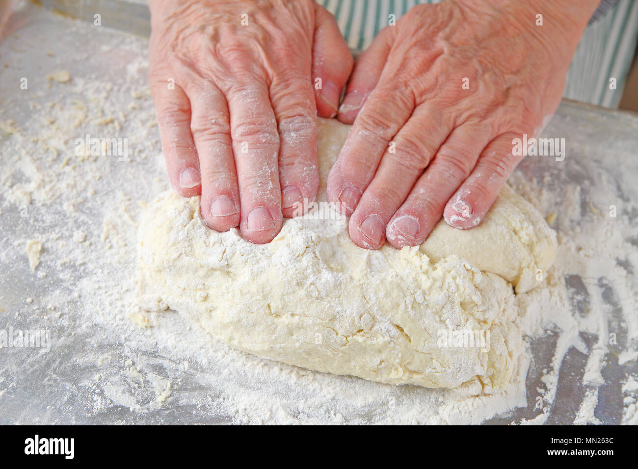 Overhead view of man pressing dough to a uniform thickness Stock Photo ...