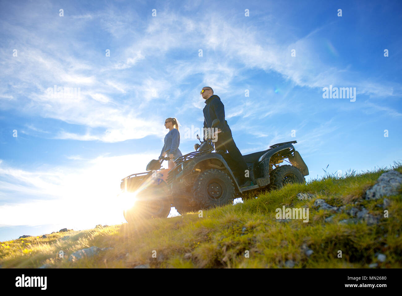 Beautiful couple is watching the sunset from the mountain sitting on ...