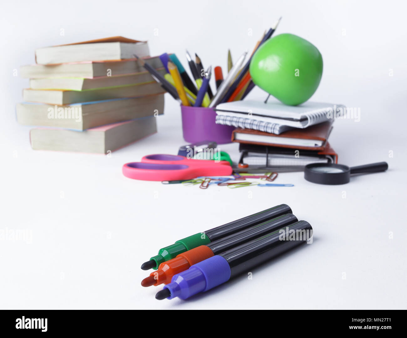 colored markers and school supplies on a white background .concept of ...