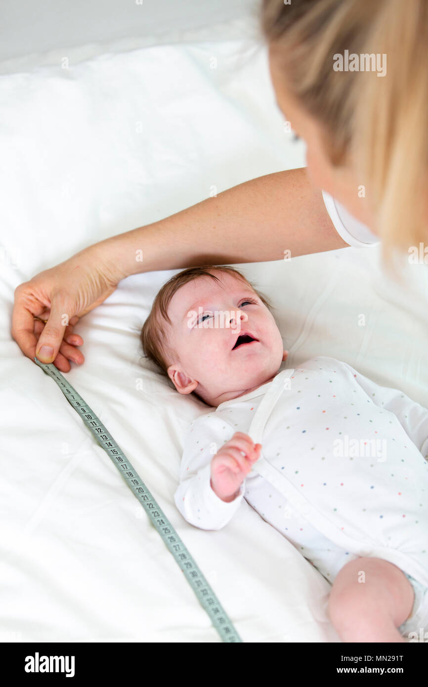 Baby is being measured by mother, doctor, woman Stock Photo - Alamy