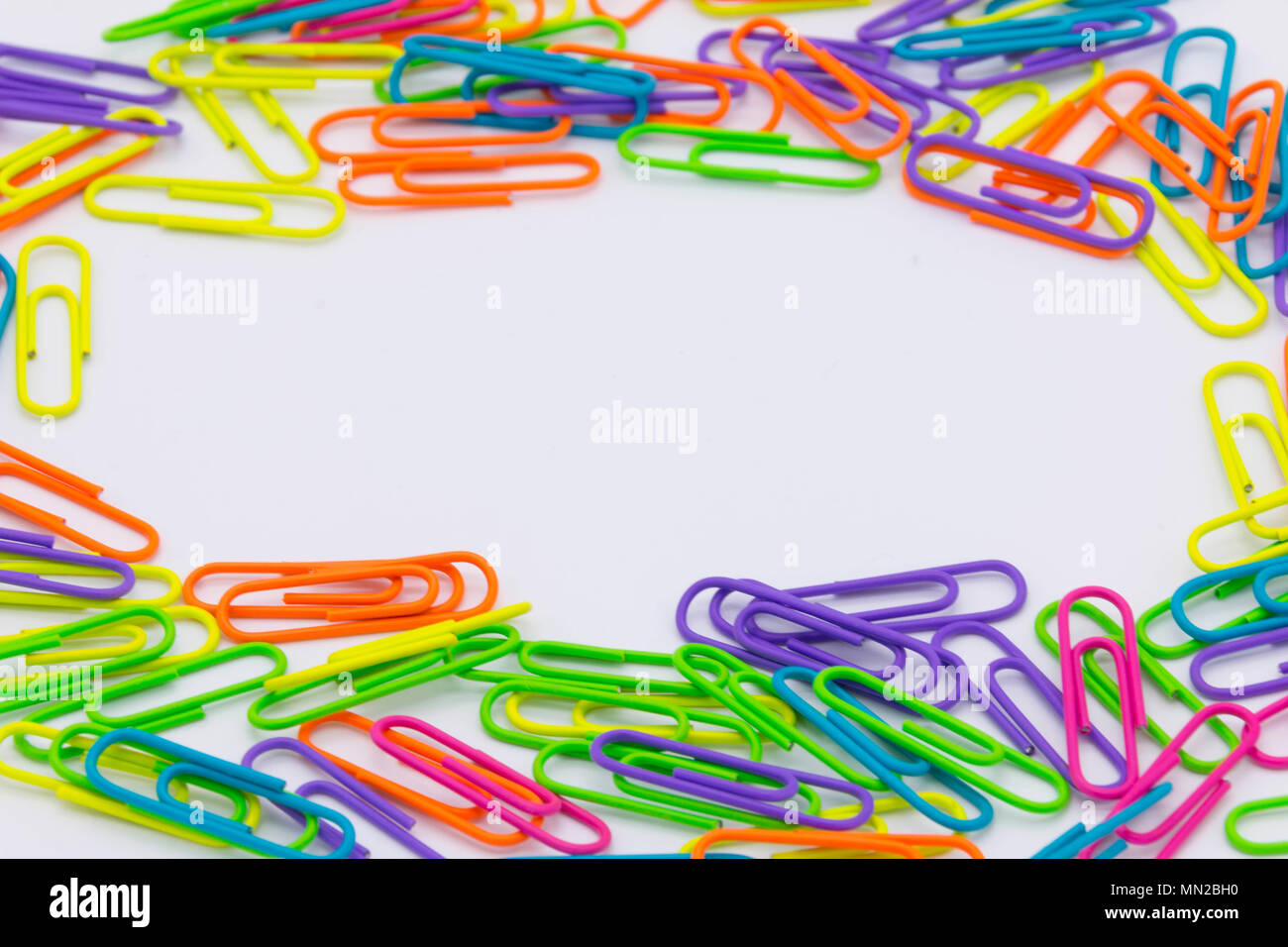 A pile of brightly coloured paper clips on a white background Stock ...