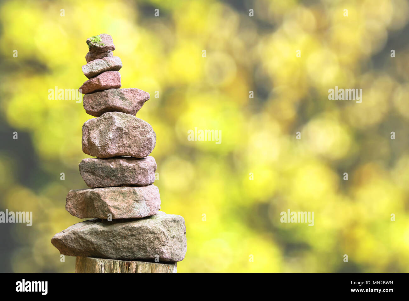 Stacked stone pyramid in front of green blurry background and bokeh ...