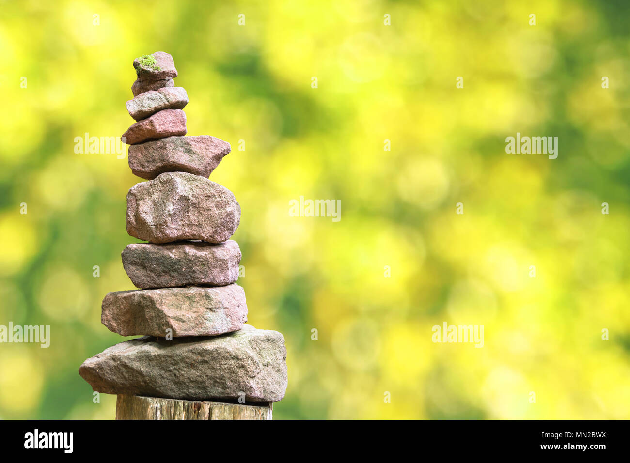 Stacked stone pyramid in front of green blurry background with bokeh ...