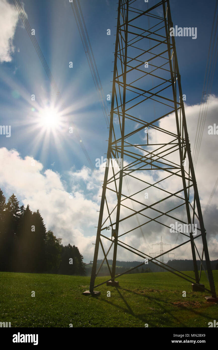 Solar energy: sunbeam on a meadow with a high voltage pylon Stock Photo ...