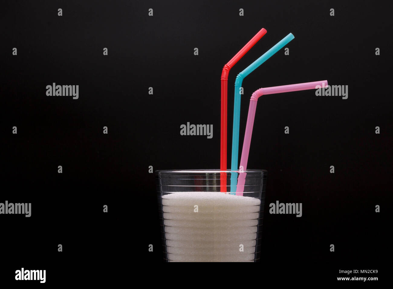 Sugar tax / levy in the uk depicted by a glass of sugar with drinking ...