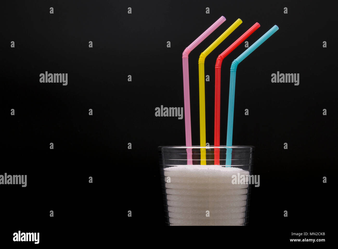 Sugar tax / levy in the uk depicted by a glass of sugar with drinking ...