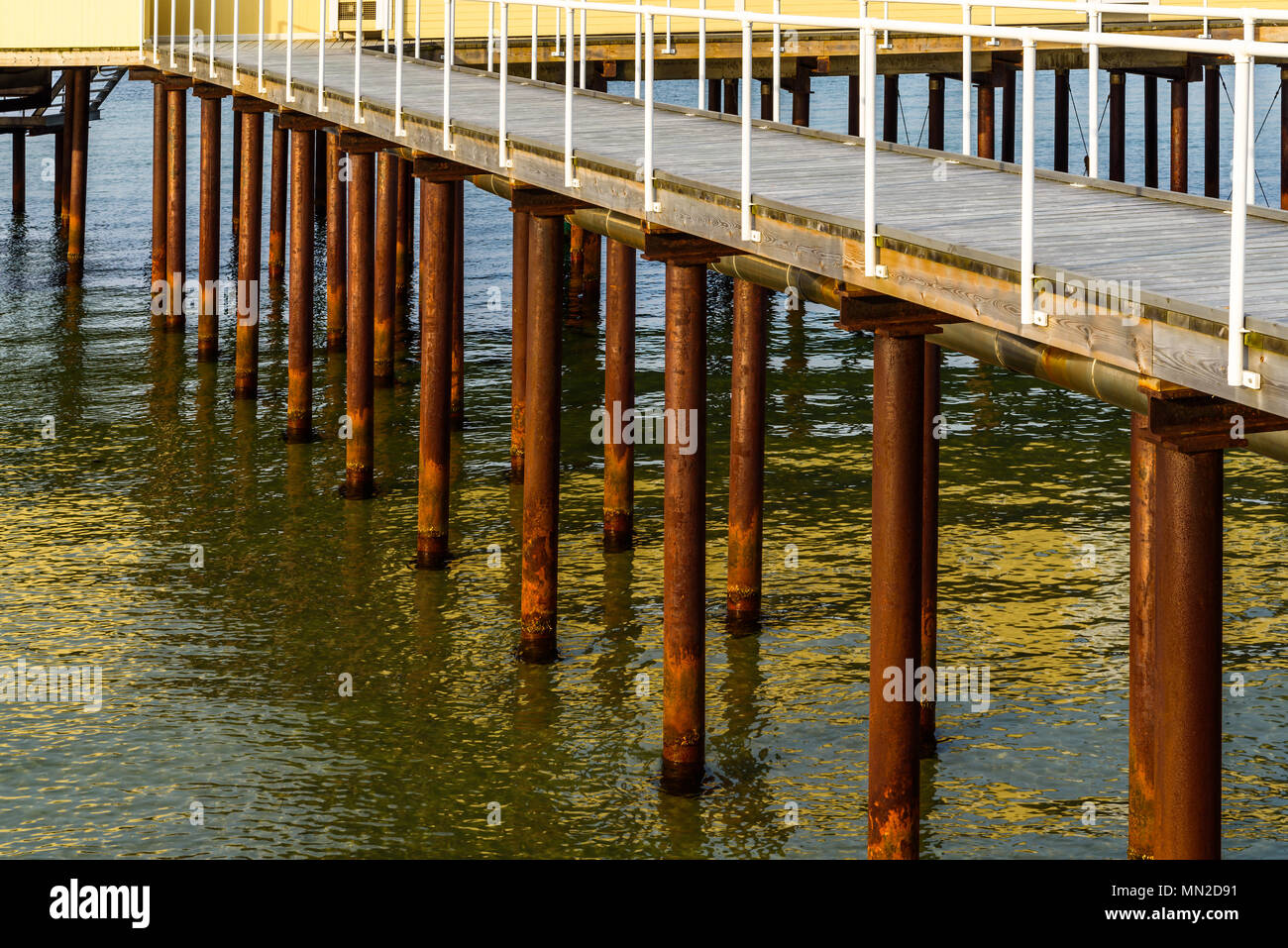 Brown and rusty iron poles underneath a wooden pier Stock Photo - Alamy