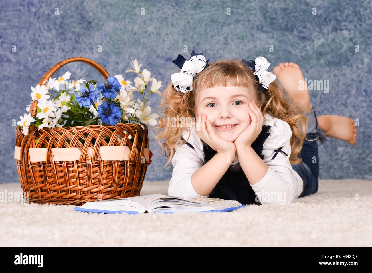 little girl reading book while lying on floor Stock Photo - Alamy