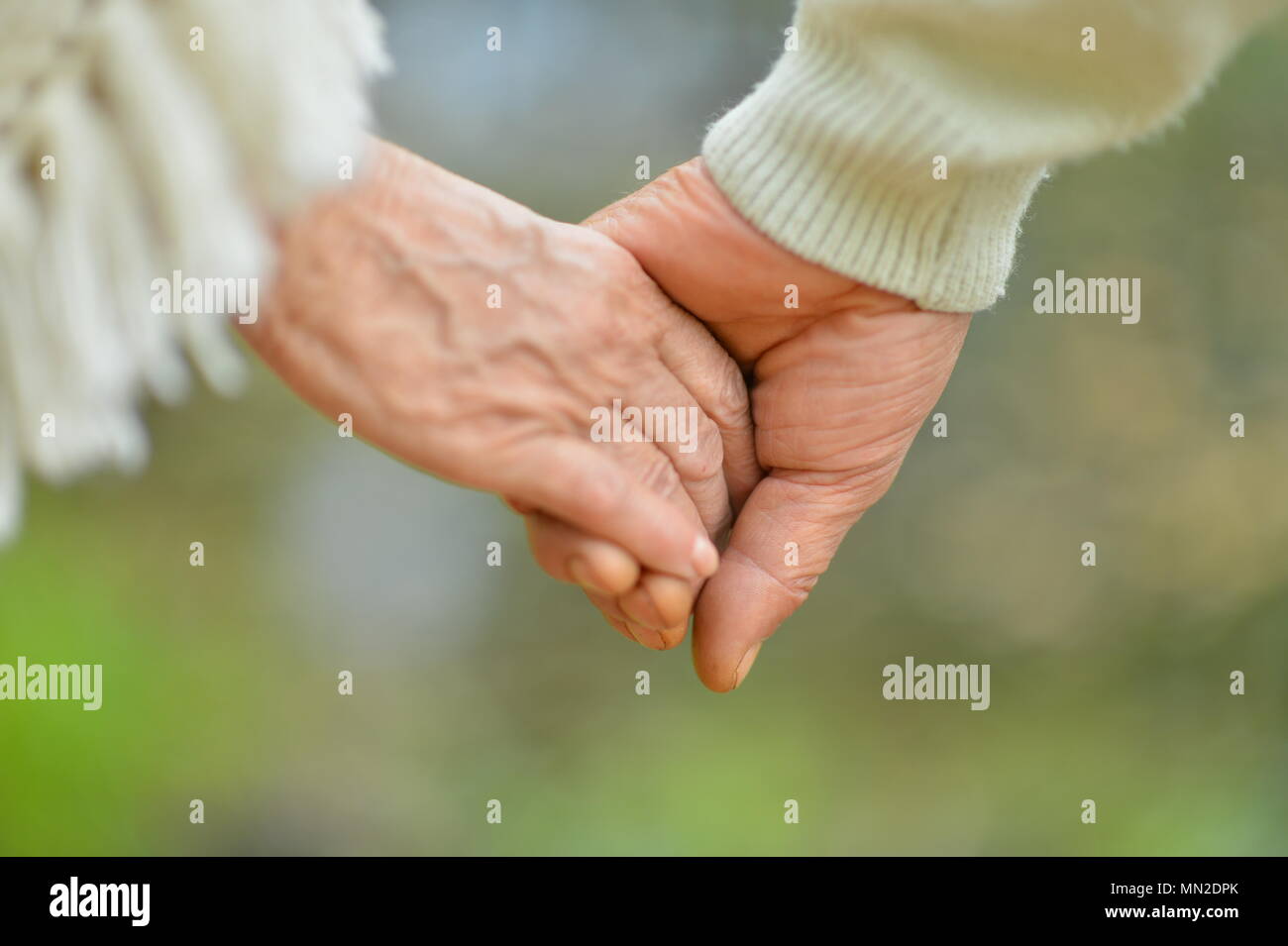 Elderly couple holding hands Stock Photo - Alamy