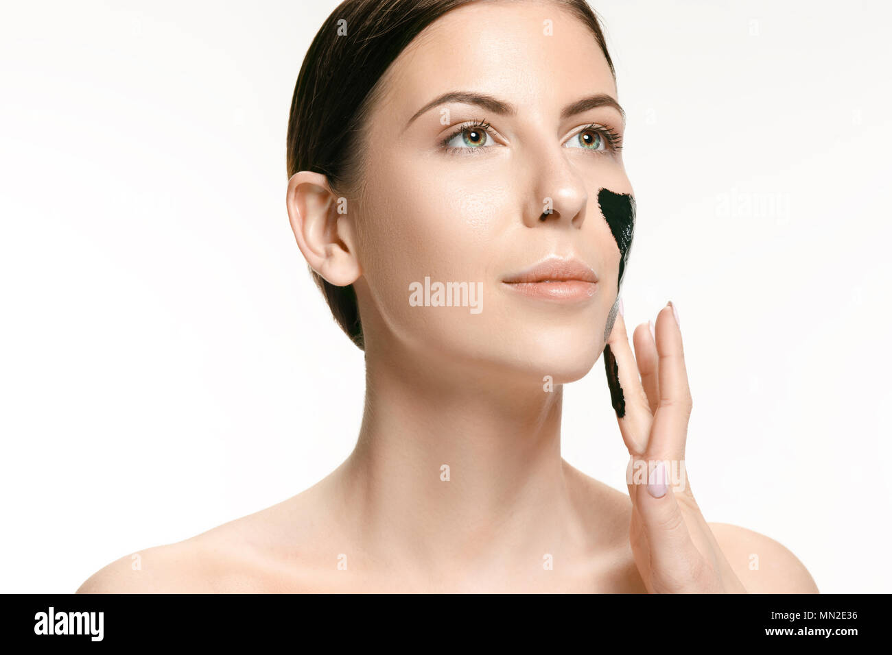 Young beautiful woman applying a mask for the face of the therapeutic ...