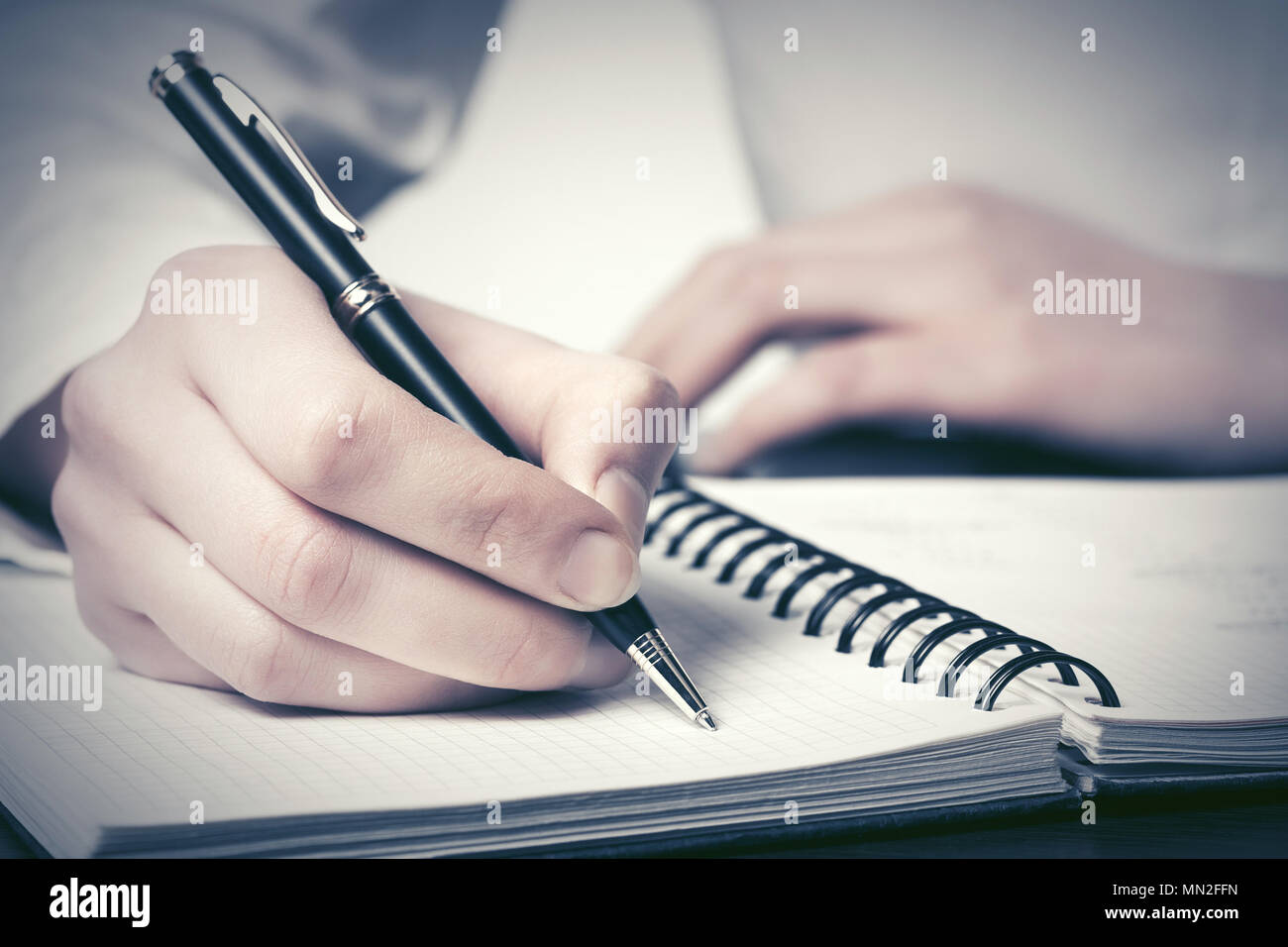 Business woman writing in notebook Stock Photo - Alamy