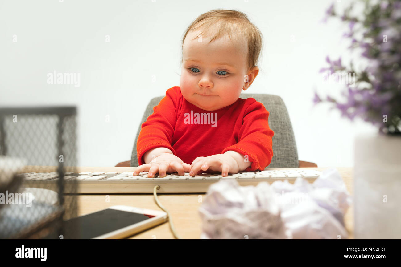 Happy child baby girl toddler sitting with keyboard of computer ...