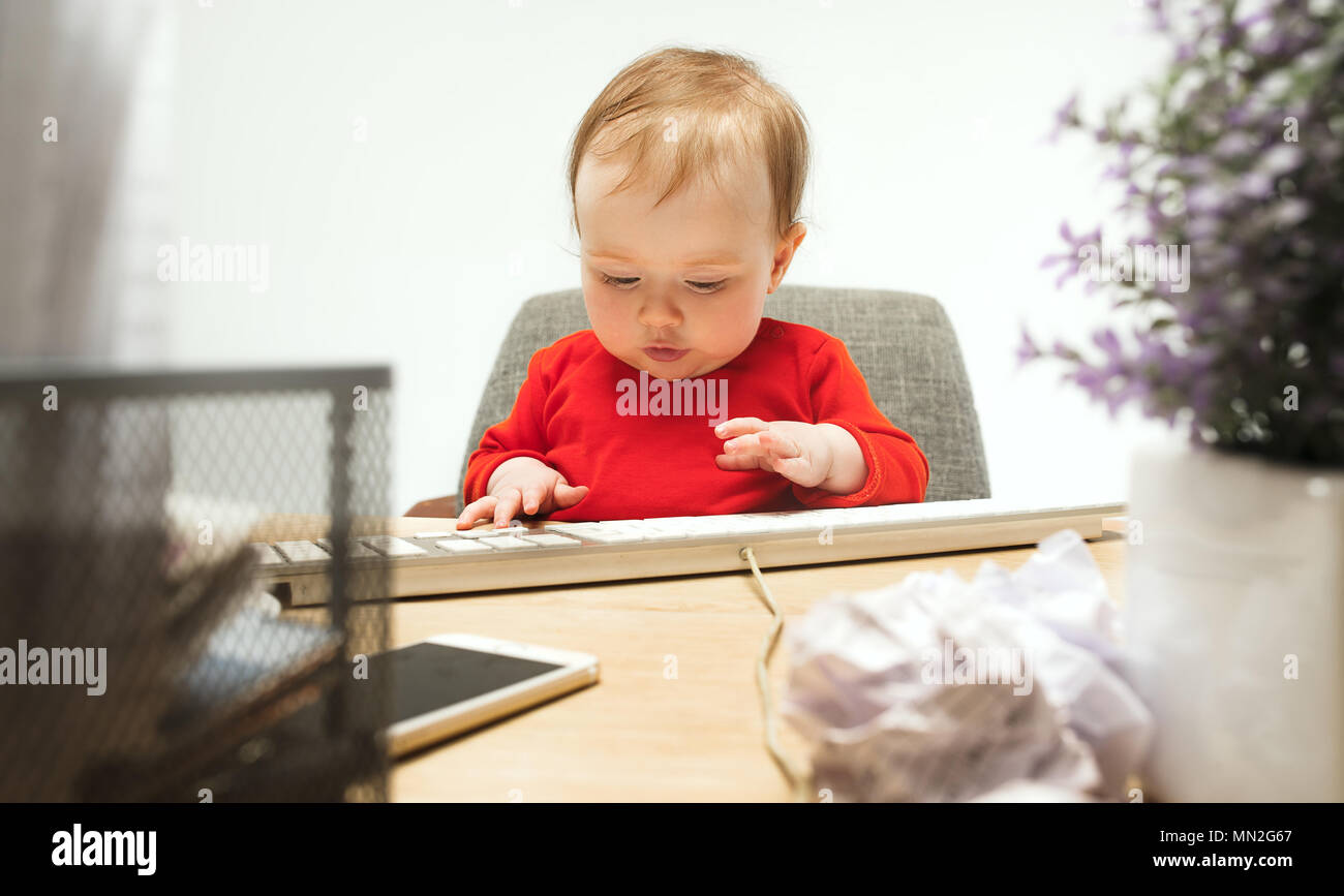 Happy child baby girl toddler sitting with keyboard of computer ...