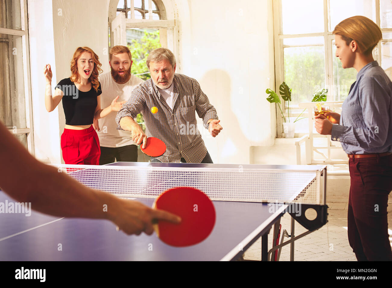 Group of happy young friends playing ping pong table tennis Stock Photo ...
