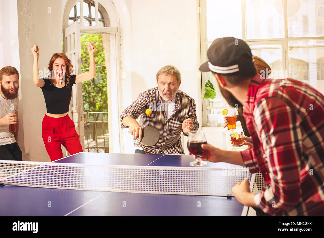 Group of happy young friends playing ping pong table tennis Stock Photo ...