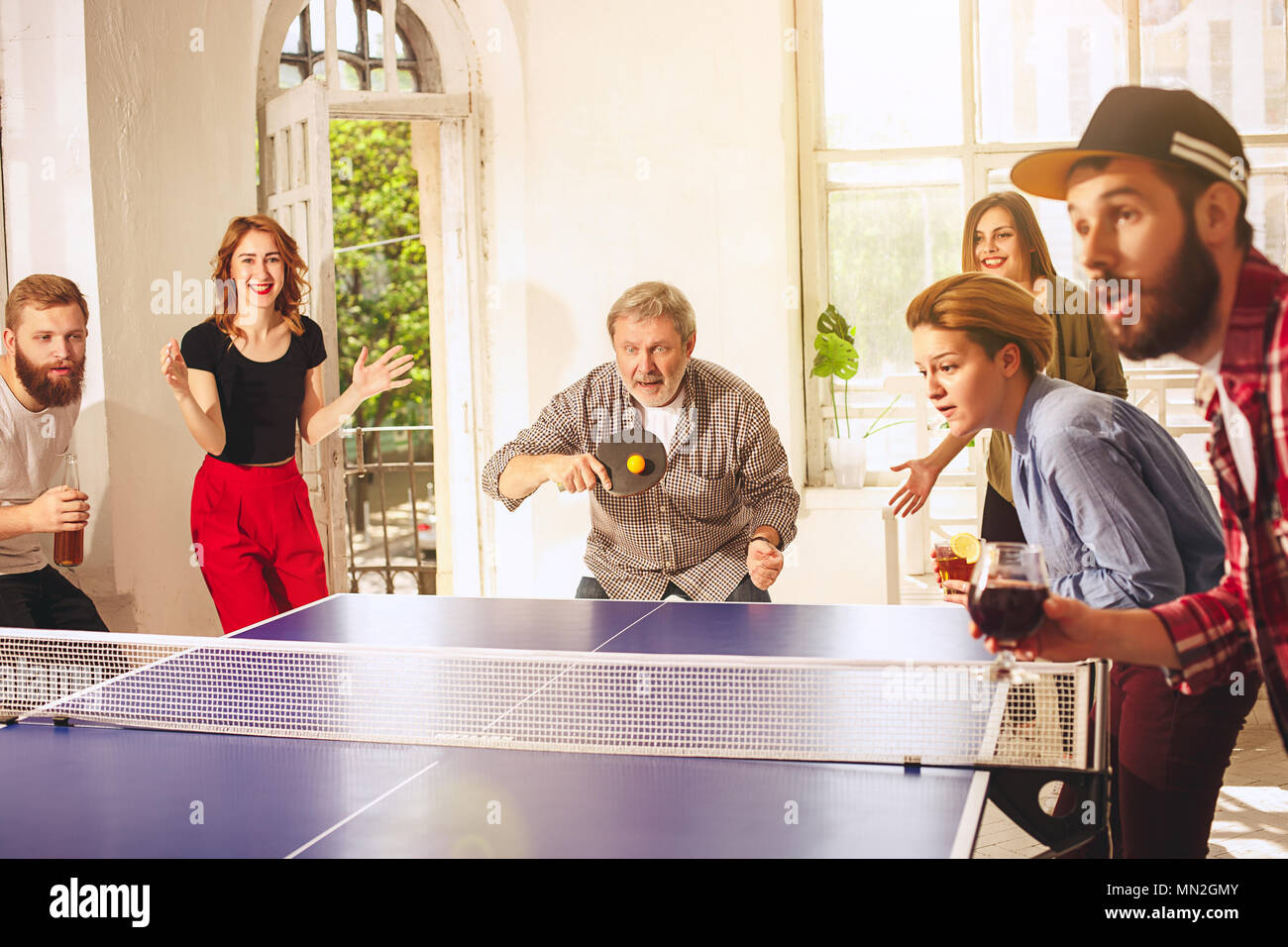 Group of happy young friends playing ping pong table tennis Stock Photo ...