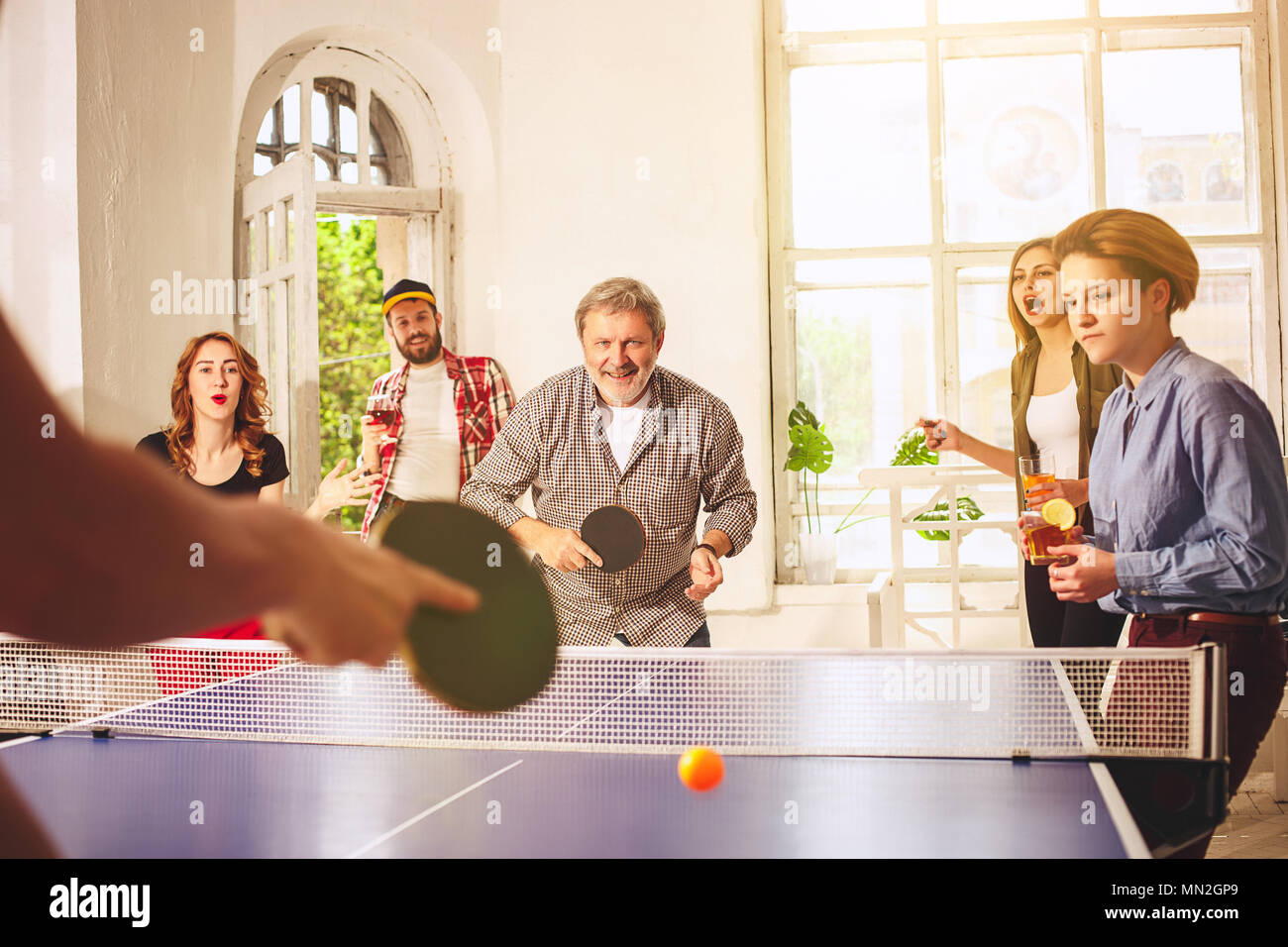 Group of happy young friends playing ping pong table tennis Stock Photo ...