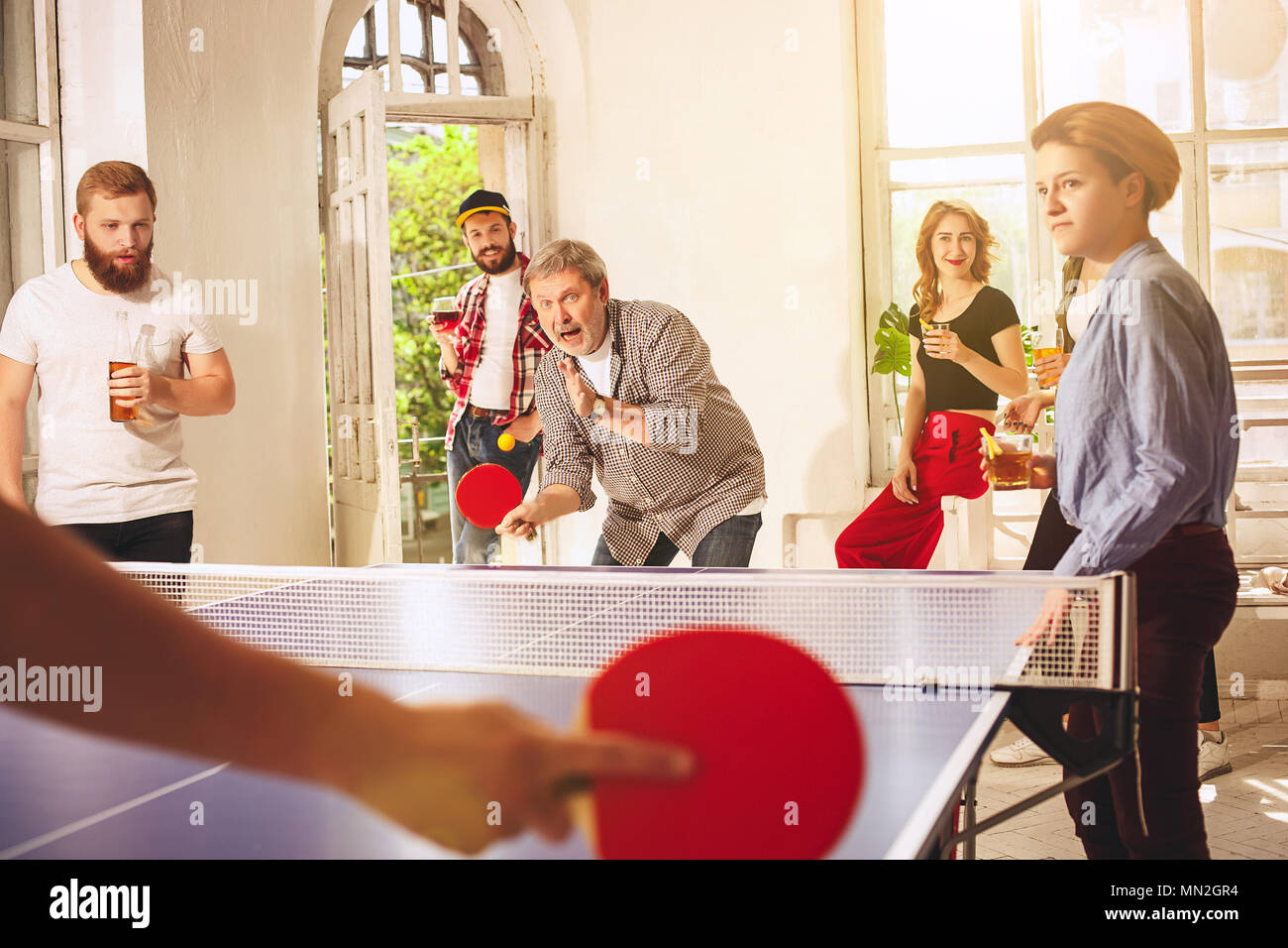 Group of happy young friends playing ping pong table tennis Stock Photo ...