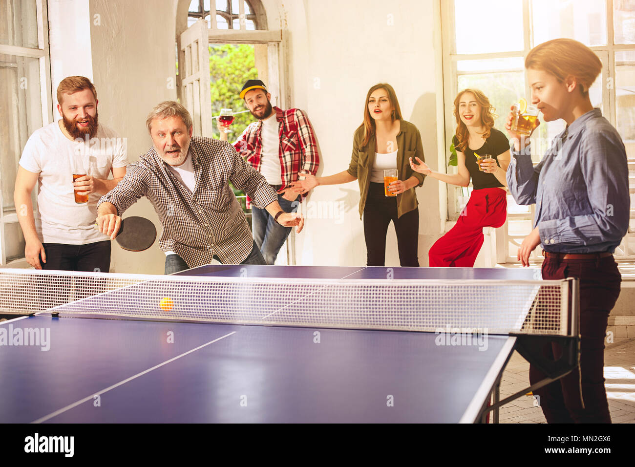 Group of happy young friends playing ping pong table tennis Stock Photo ...