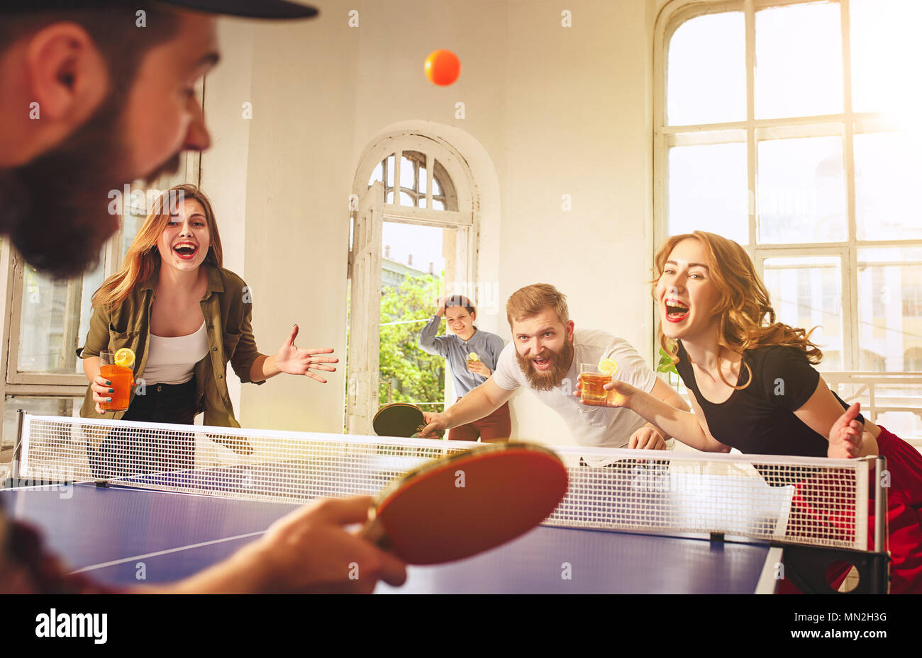 Group of happy young friends playing ping pong table tennis Stock Photo ...