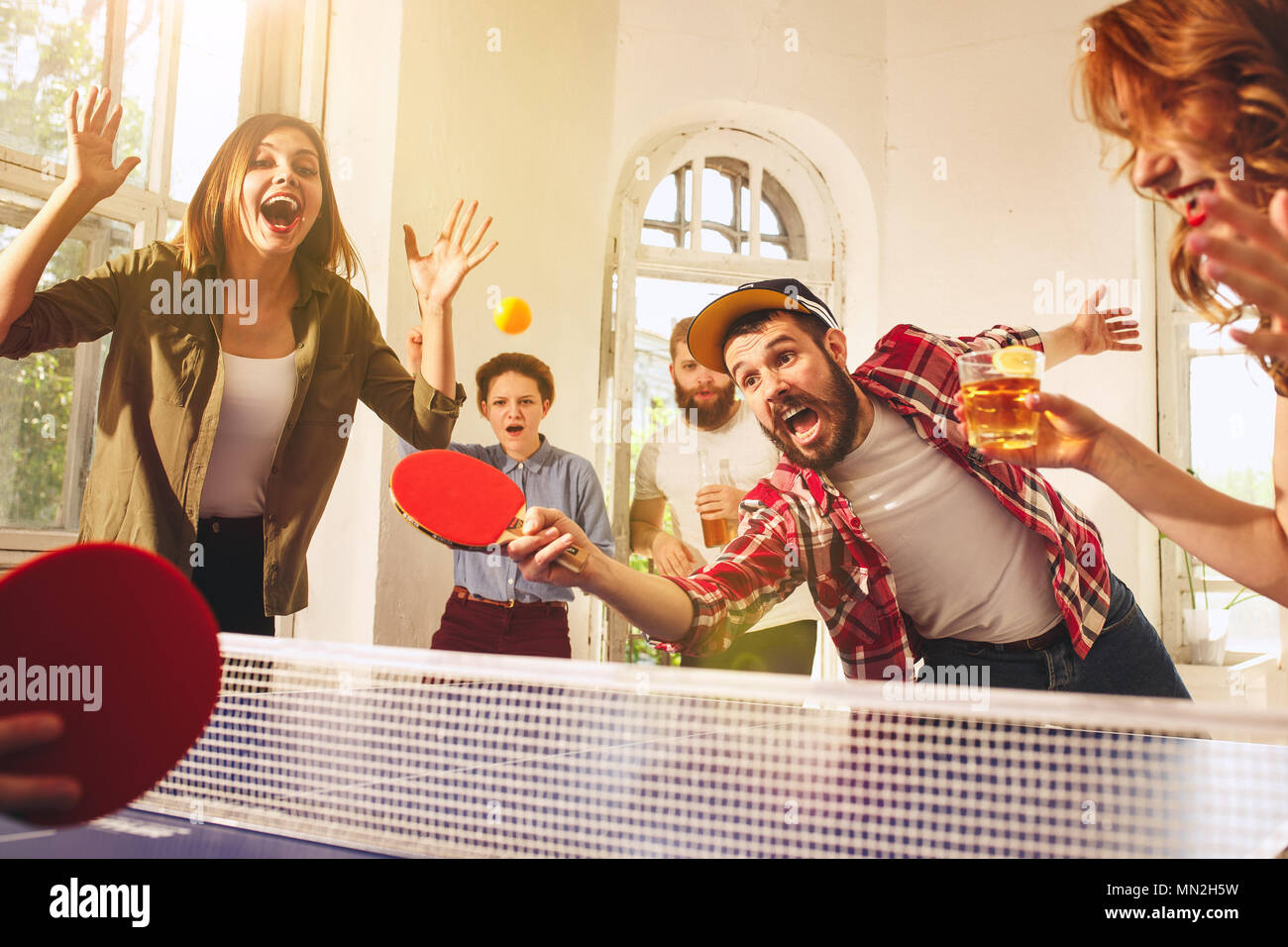 Group of happy young friends playing ping pong table tennis Stock Photo ...