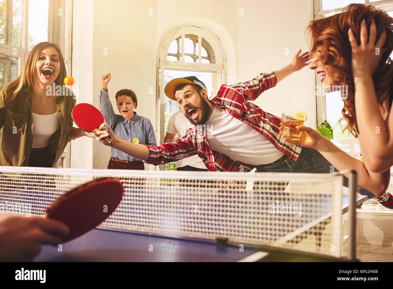 Group of happy young friends playing ping pong table tennis Stock Photo ...
