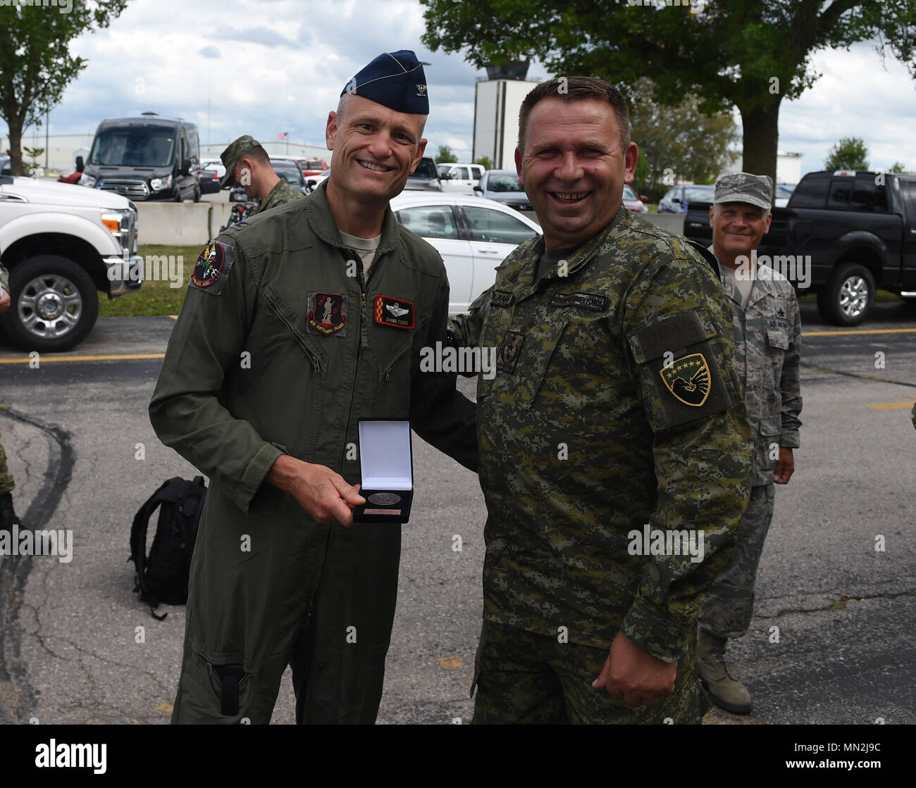 Col. Shawn Ford, commander 132d Wing (left), recieves a coin from Lt ...