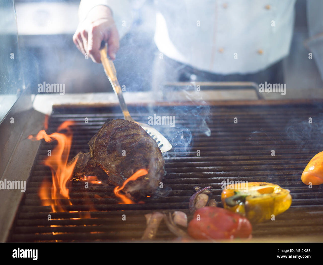 Master chef cooking delicious grilled meat steak with vegetables on a ...