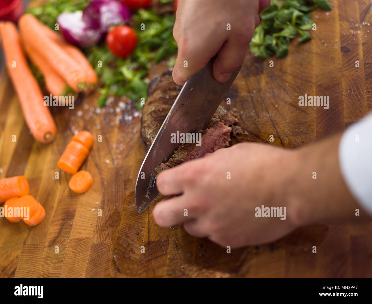 closeup of Chef hands in hotel or restaurant kitchen preparing beef ...