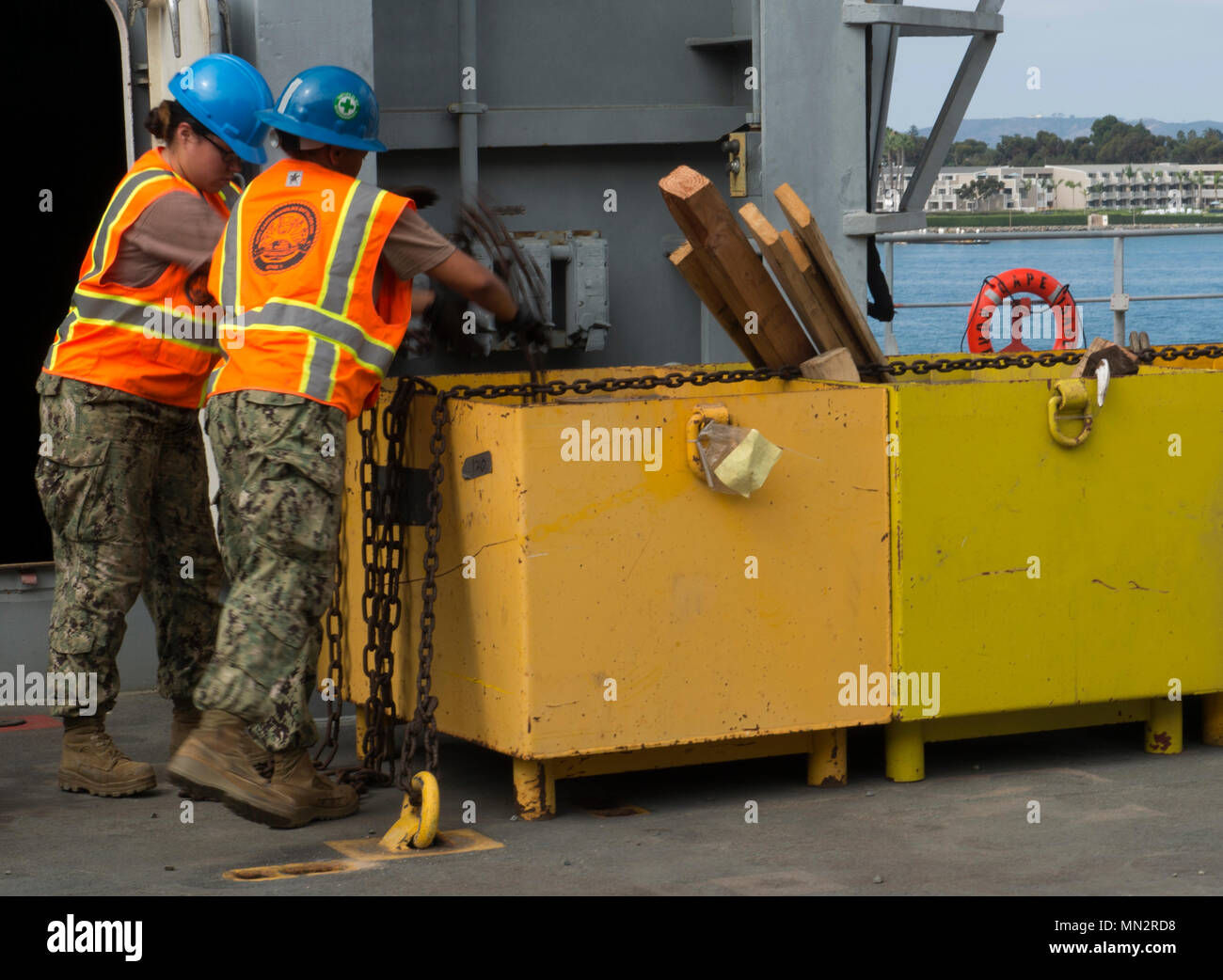 U.S. Navy Seamen from the Navy Cargo Handling Battalion One load chains ...