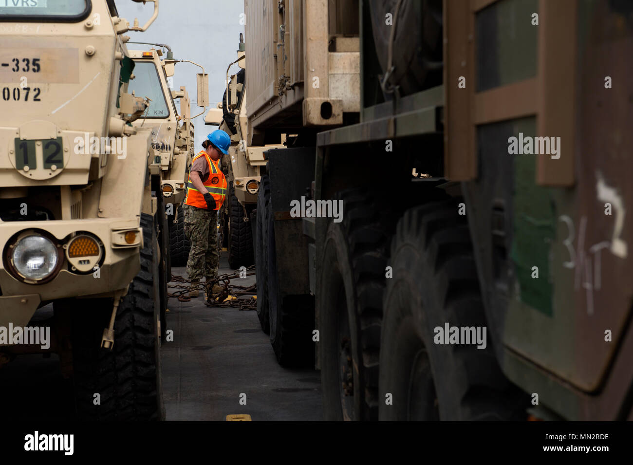 A U.S. Navy Seaman from the Navy Cargo Handling Battalion One unchains ...