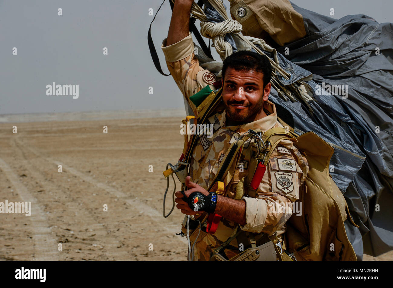 A Qatari service members walks with his parachute after conducting a ...