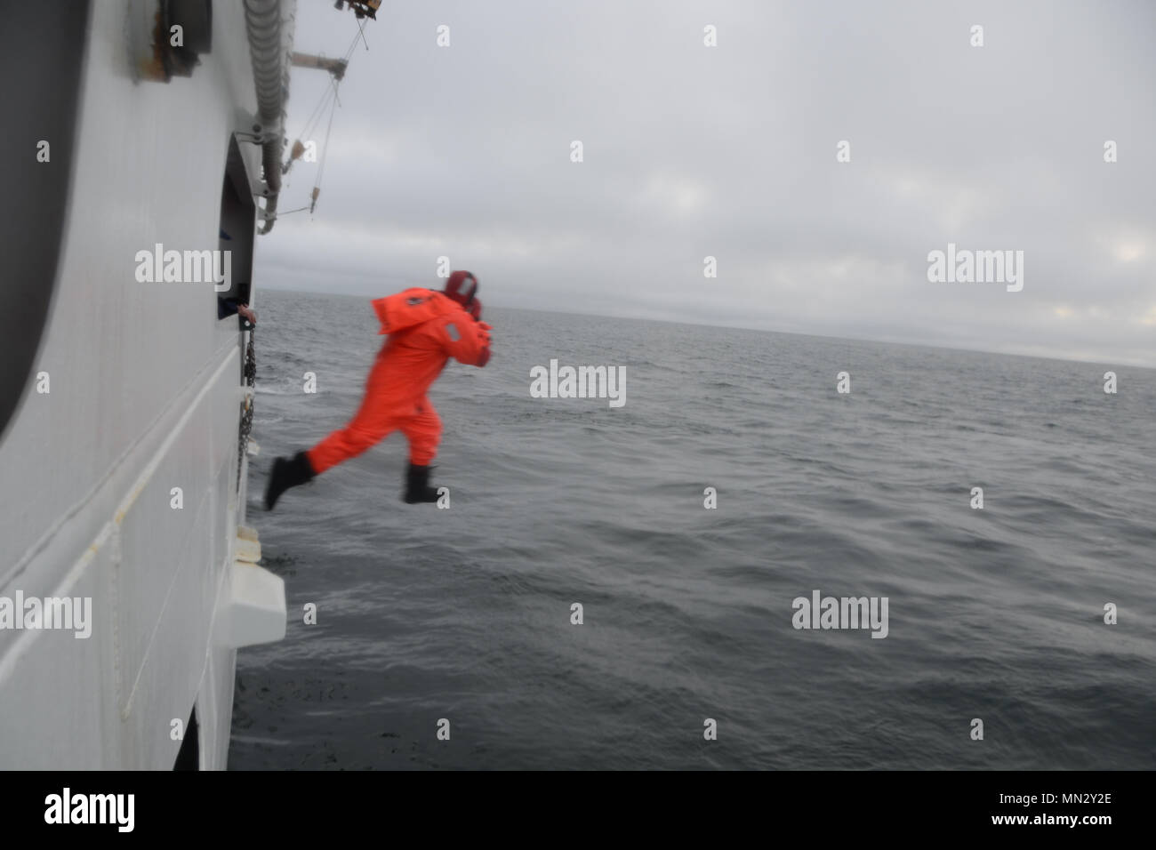 A crewmember aboard the Coast Guard Cutter Alex Haley leaps into the ...