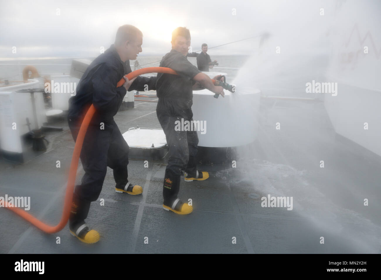 Crewmembers aboard the Coast Guard Cutter Alex Haley attempt to quench ...