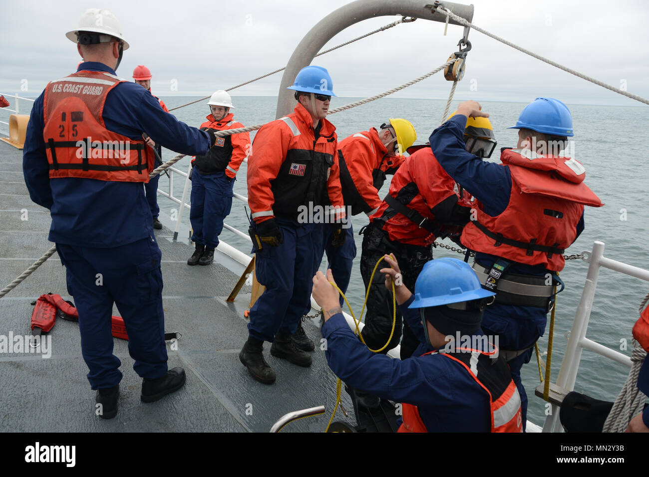 Crewmembers aboard the Coast Guard Cutter Alex Haley haul up a cutter ...