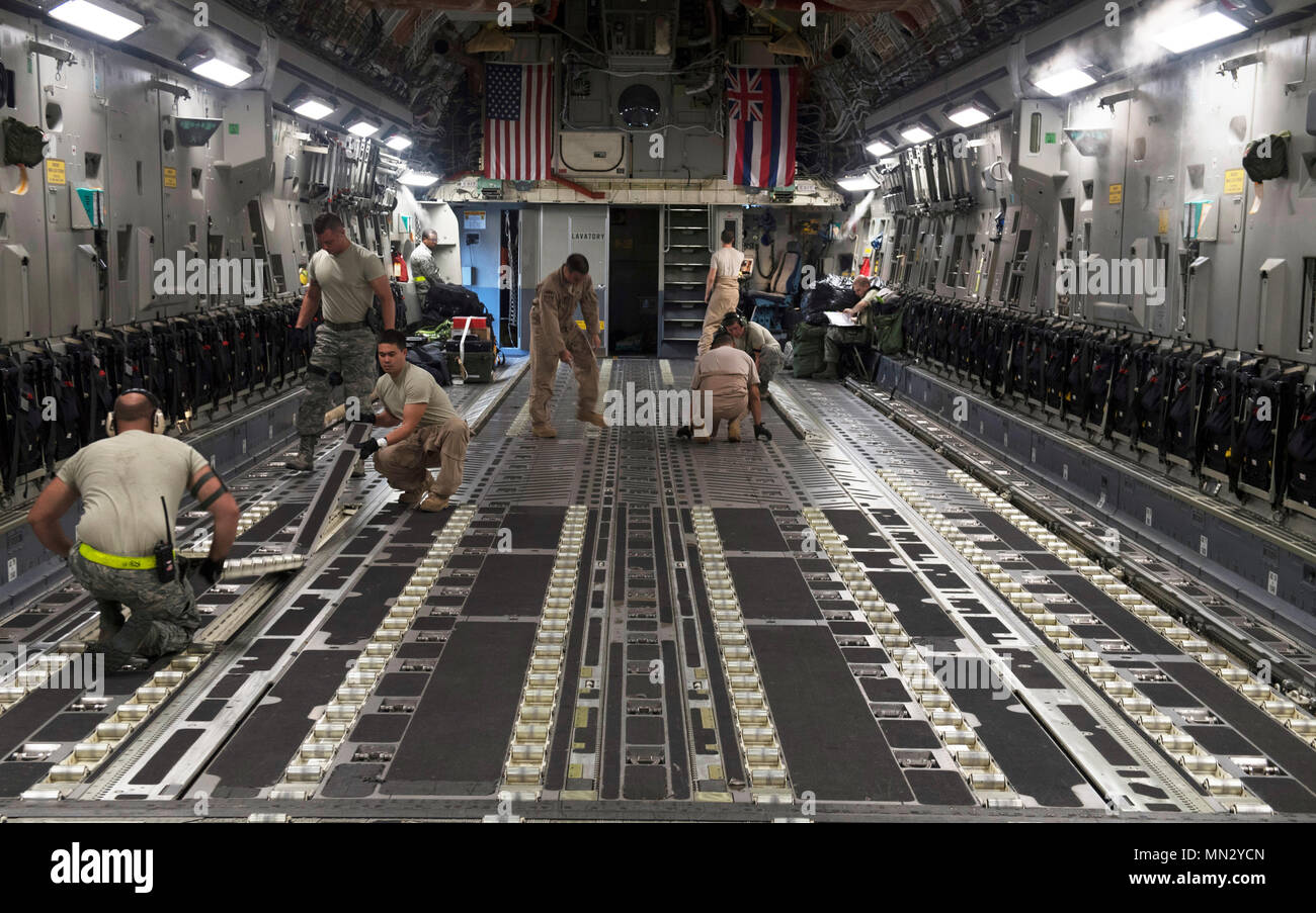 Airmen flip roller assembles inside the aircraft to load cargo on to a ...