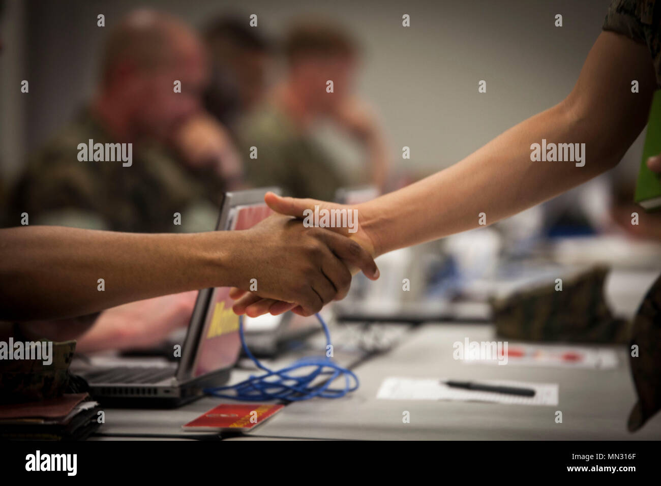 A U.S. Marine and their monitor shake hands after finishing an ...