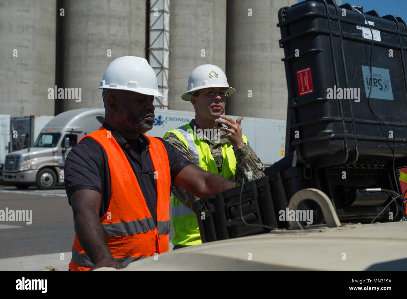 Civilian contractors demonstrate a portable deployment kit training as ...